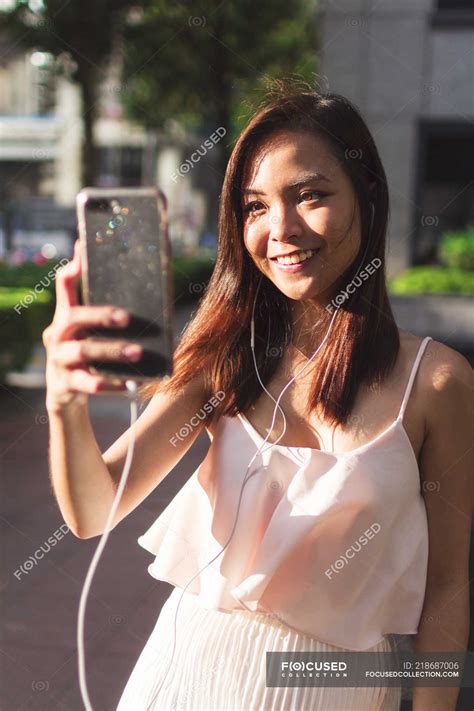 Pretty Asian Girl Taking A Selfie In The Street Outdoors Mobile