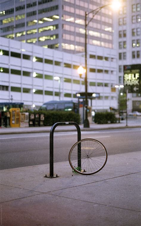 Bike Wheel Chained To A Bike Rack By Stocksy Contributor Lucas