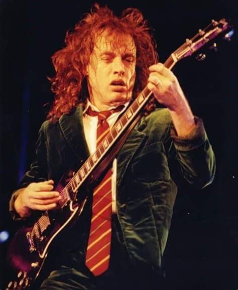 A Man With Long Hair Playing An Electric Guitar