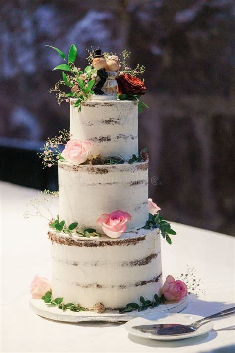 Wedding Naked Cake Decorated With Flowers And Greenery On A Cake Stock