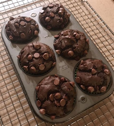 Six Chocolate Muffins On A Cooling Rack Ready To Be Baked In The Oven