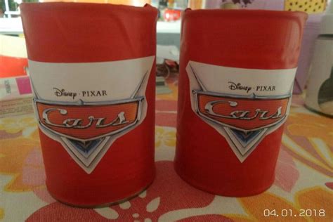 Two Red Cups Sitting On Top Of A Table Next To Each Other With Cars