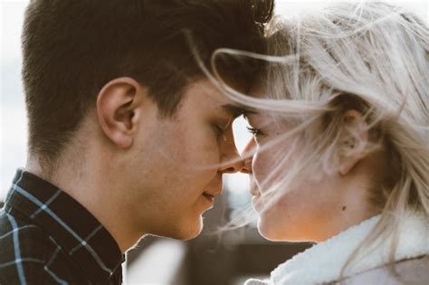 Le garçon regarde tendrement la fille et veut embrasser Un jeune