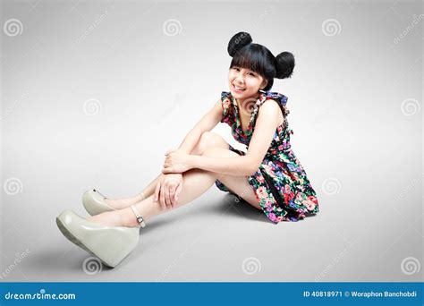 Fille Asiatique Adolescente De Sourire S Asseyant Sur Le Plancher Image