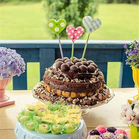 A Table Topped With Lots Of Cakes And Flowers