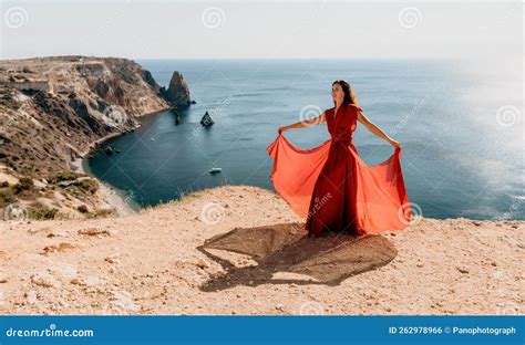 Woman In Red Dress On Sea Side View A Young Beautiful Sensual Woman In A Red Long Dress Posing