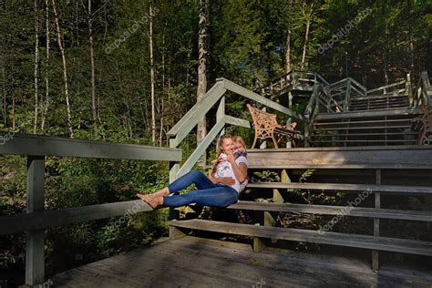 Mamá y su hija están descansando sentadas en las escaleras del sendero