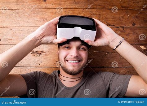 Man Wearing Virtual Reality Goggles Studio Shot Wooden Backgro Stock