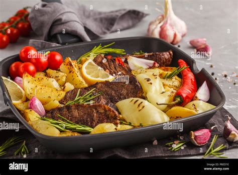 Rindersteaks vom Grill mit gebackenen Kartoffeln und Gemüse in einer