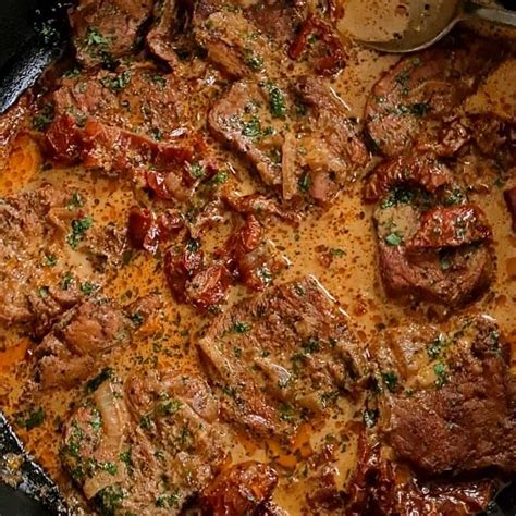 A Pan Filled With Meat And Sauce On Top Of A Stove