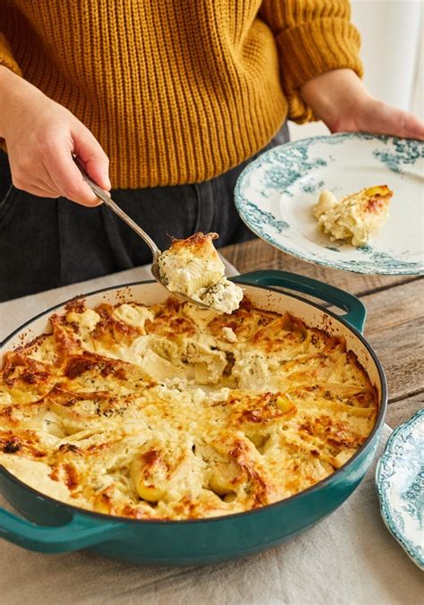 A Person Holding A Spoon With Some Food In It On A Plate And Another