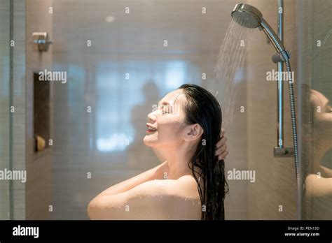 Young Asian Woman Taking A Shower In The Bathroom With Shower Head Looking Happy And Relax