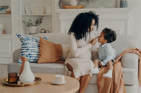 Premium Photo Mother And Son Sitting On Sofa