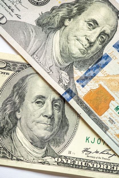 Un billete de un dólar y un billete de 100 dólares están alineados uno