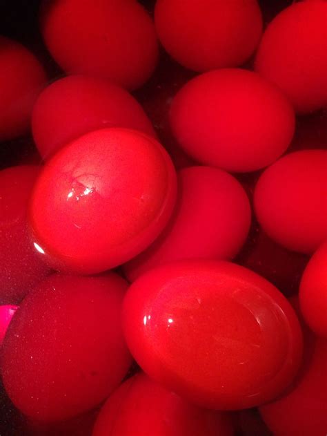 Some Red Balls In A Black Bowl With Water On The Bottom And One Pink