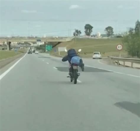 Motociclista é flagrado deitado em cima de moto em rodovia vídeo