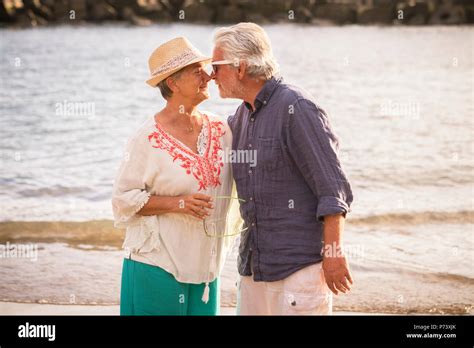 beautiful senior mature couple enjoy with kiss and hug the outdoor leisure activity at the beach