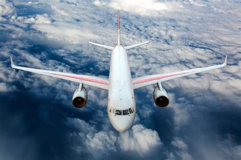 Passenger Plane Fly High In The Sky Above The Clouds Front View Stock