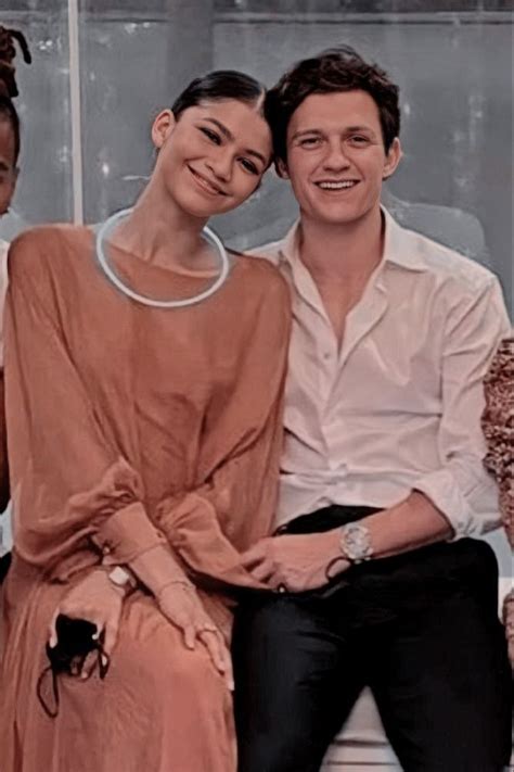 Three People Sitting Next To Each Other Posing For A Photo With Their