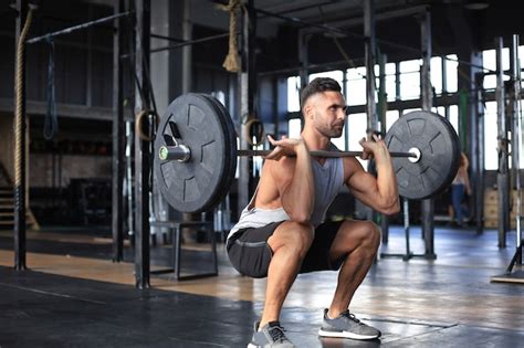 Premium Photo Muscular Man Working Out In Gym Doing Exercises With