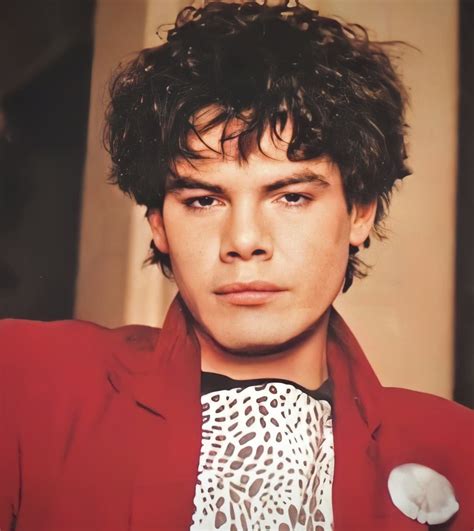 A Close Up Of A Person Wearing A Red Jacket And White Shirt With Black Hair