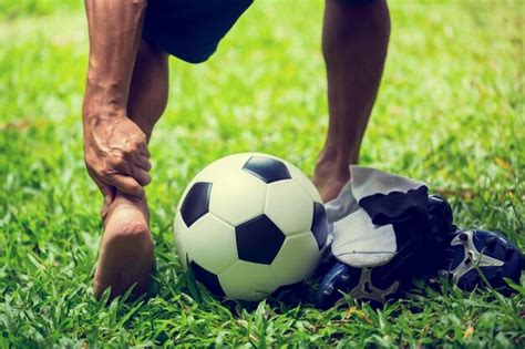Premium Photo Low Section Of Man Playing Soccer Ball On Grass