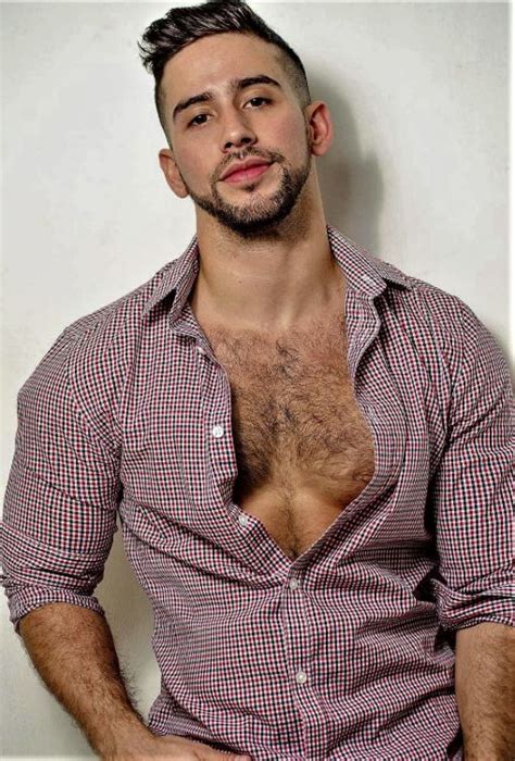 A Shirtless Man With His Hands On His Hips Looking At The Camera While