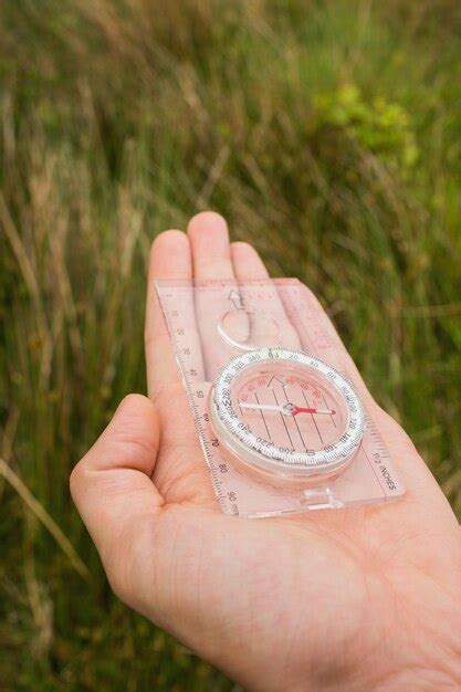 Mano femenina que sostiene la brújula moderna que muestra el camino