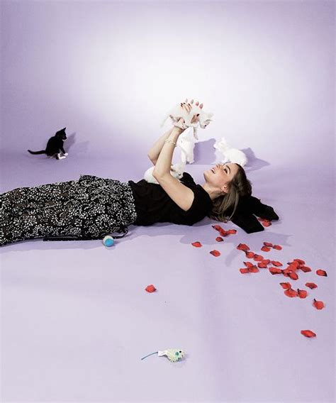 A Woman Laying On The Ground Surrounded By Confetti And Petals With A