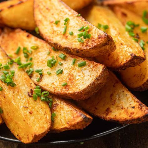 Close Up Of Air Fryer Potato Wedges Topped With Fresh Chives