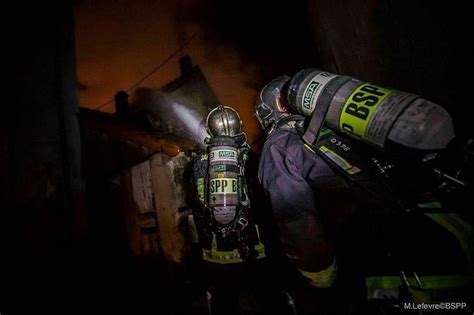 Two Fire Fighters In The Dark With Their Hoses On