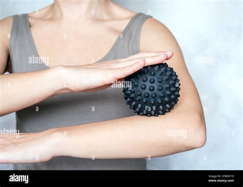 A Young Woman Massages Her Elbow With Spiky Trigger Point Ball Tennis Elbow Exercises