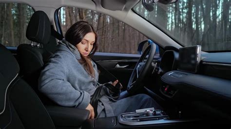 Lady driver abrocha el cinturón de seguridad sentado en el volante del
