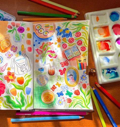 An Open Coloring Book Sitting On Top Of A Wooden Table Next To Colored