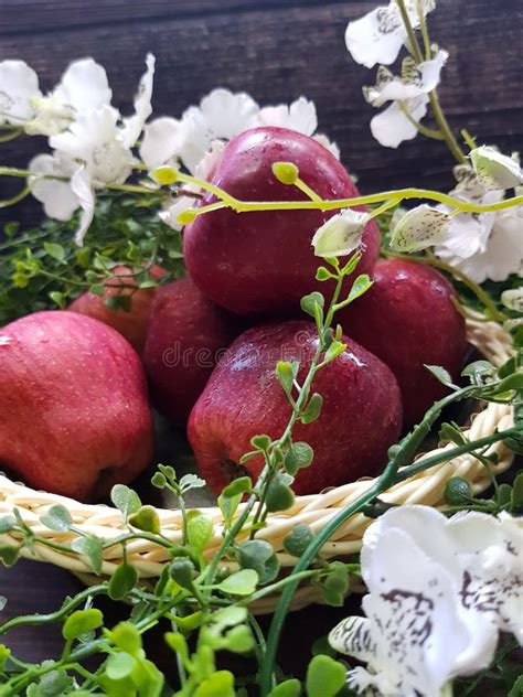 Manzanas Rojas En La Cesta Con Flores Y Hojas Imagen De Archivo