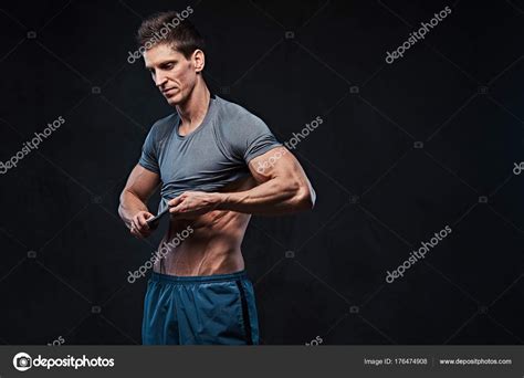Studio Portrait Ectomorph Muscle Shirtless Male Takes Shirt Shows