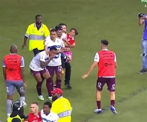Notícias Torcedor invade campo criança no colo e agride jogador