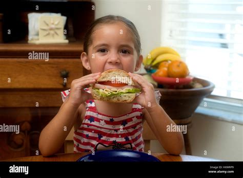 Jeune fille mangeant un sandwich Banque de photographies et dimages à