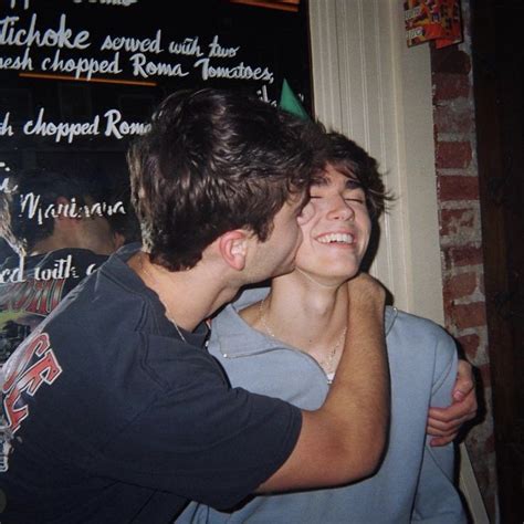 Two People Are Hugging Each Other In Front Of A Chalkboard