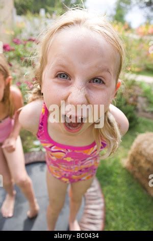 Sieben Jahre altes Mädchen spielen mit Schlauch im Garten