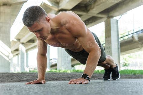 Muscular Man Is Doing Push Ups During Calisthenic Workout On A Street