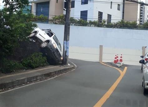 Após motorista perder controle carro fica pendurado entre calçada e