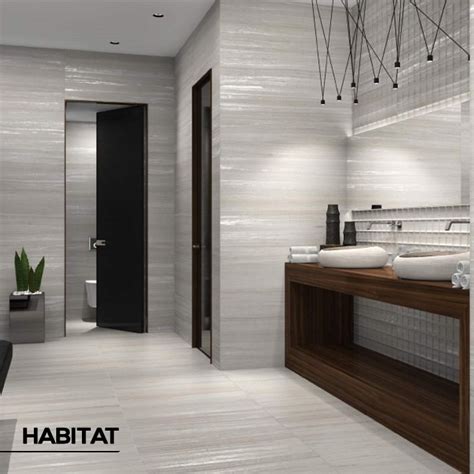 A Bathroom With White Tile And Wood Accents
