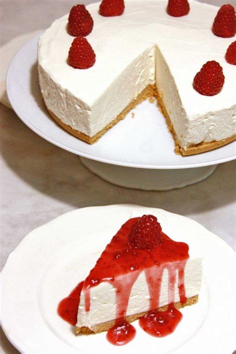A Cheesecake With Raspberries On The Top And One Slice Missing From It