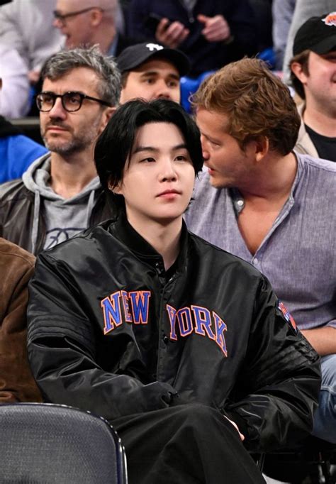Two Men Sitting Next To Each Other At A Basketball Game