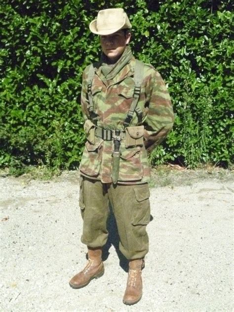 A Man In Camouflage Is Standing With His Hands On His Hips While