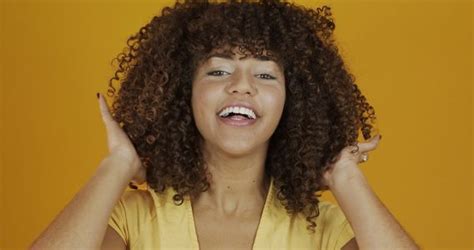 Jovem afro cabelo encaracolado sorrindo para a câmera em fundo