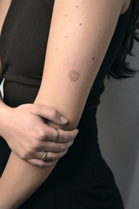 A Woman With A Small Tattoo On Her Arm