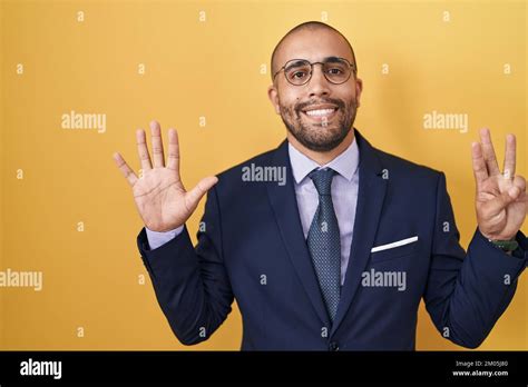 Hispanic Man With Beard Wearing Suit And Tie Showing And Pointing Up