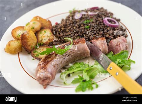 France La saucisse de Toulouse grillée avec salade et les lentilles et